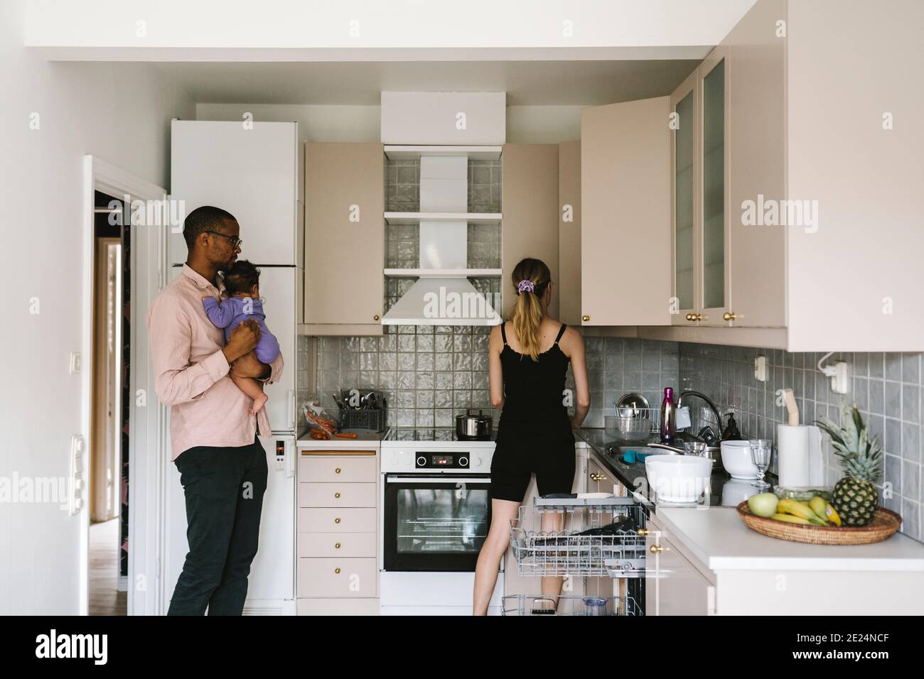 Parents with baby in kitchen Stock Photo - Alamy