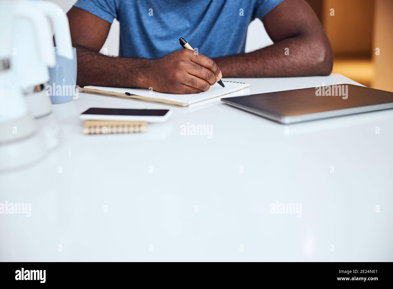 Adult man using a pen for writing in a notepad Stock Photo - Alamy