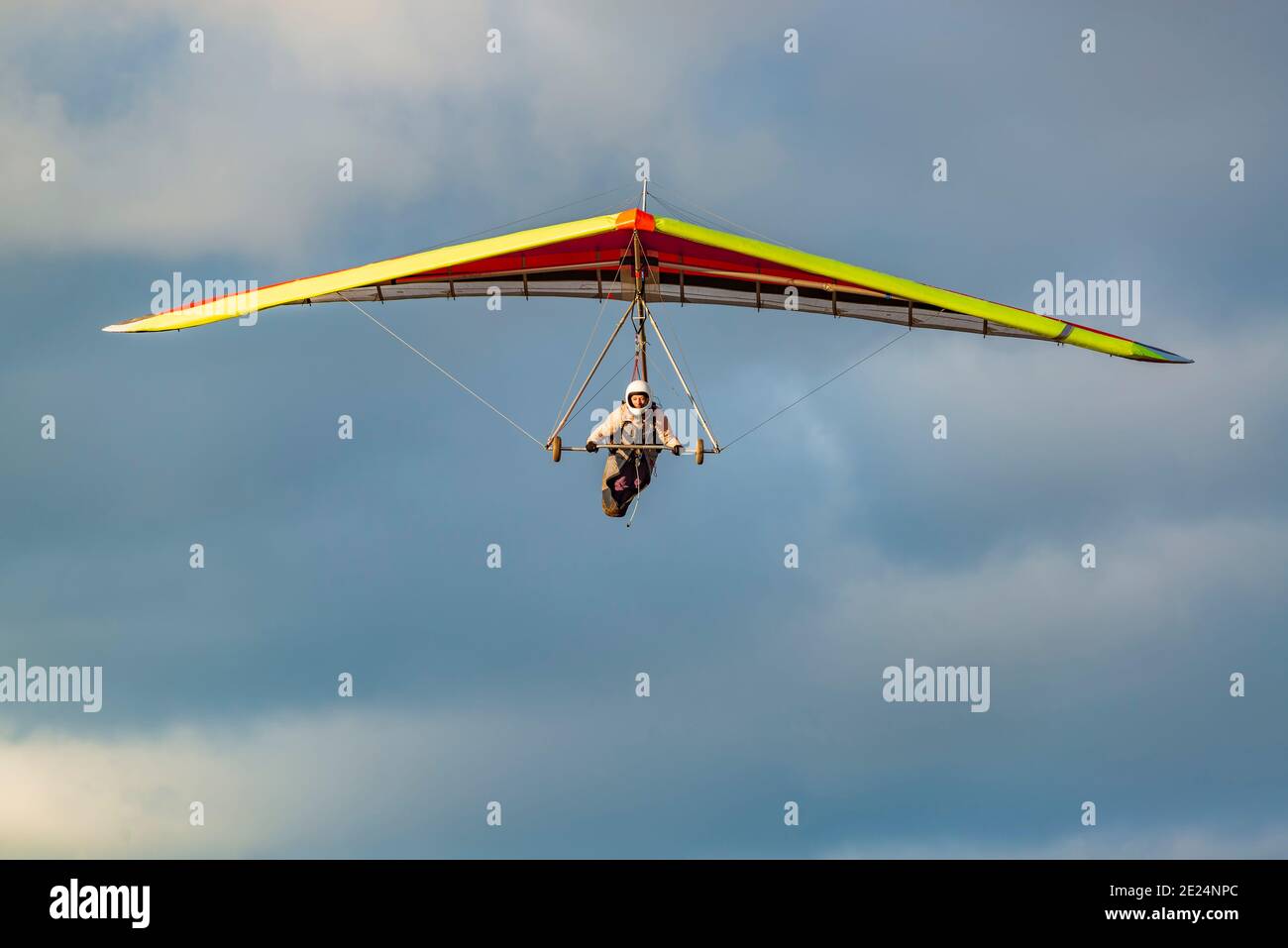 Beginner girl pilot withcolorful hang glider wing. Learning hang ...