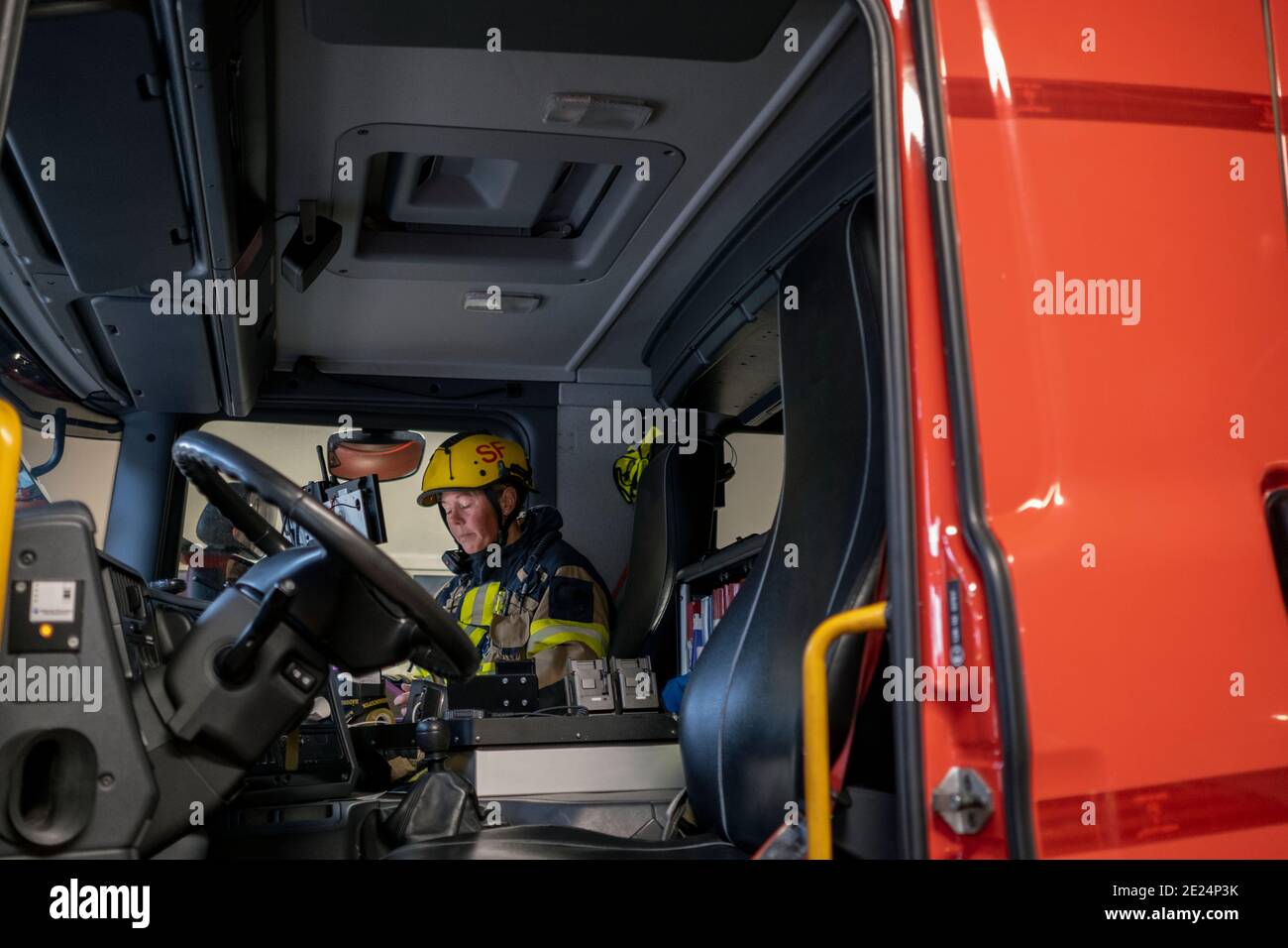 Female firefighter sitting in fire engine Stock Photo - Alamy