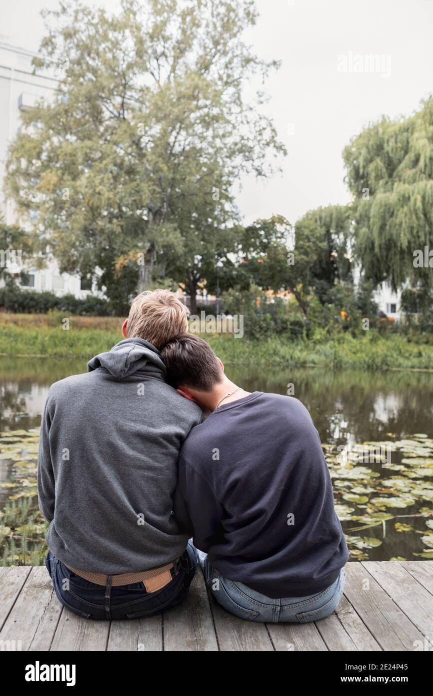 Rear view of two teenage boys sitting together Stock Photo - Alamy