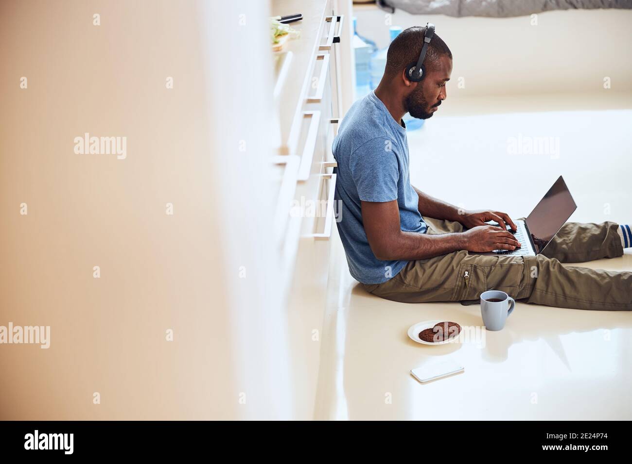 Diligent man working with laptop on a floor Stock Photo - Alamy