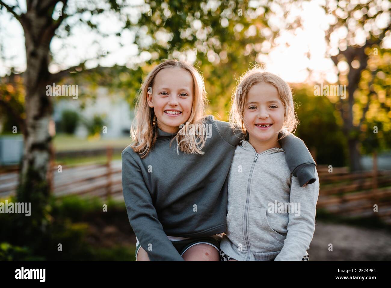 Smiling sisters looking at camera Stock Photo - Alamy