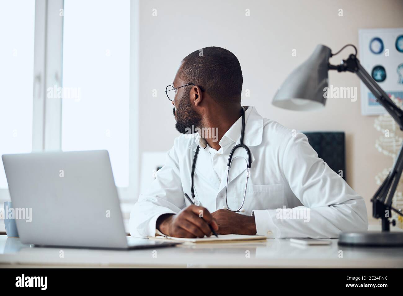 Doctor turning to the window of his office Stock Photo - Alamy