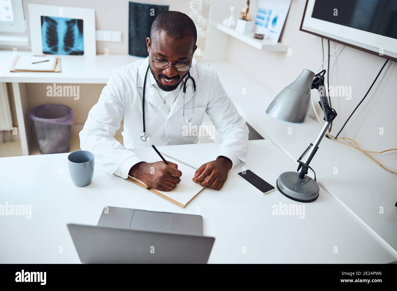 Cheerful doctor touching a sheet of paper with pencil Stock Photo - Alamy