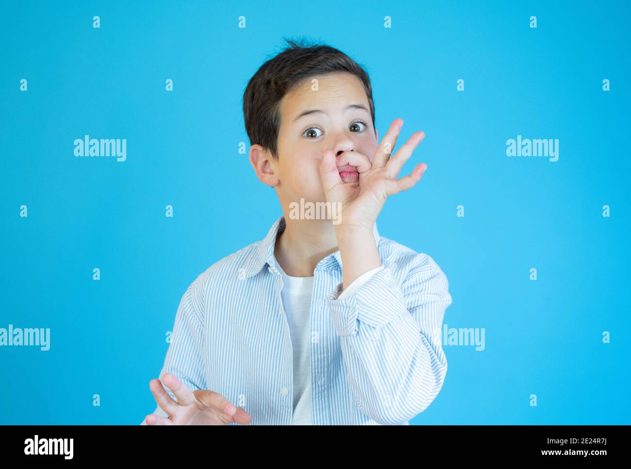 Boy showing okay gesture in sign language on blue background Stock ...