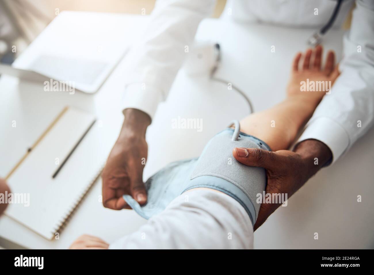 Medical person wrapping a pressure cuff around an arm Stock Photo - Alamy
