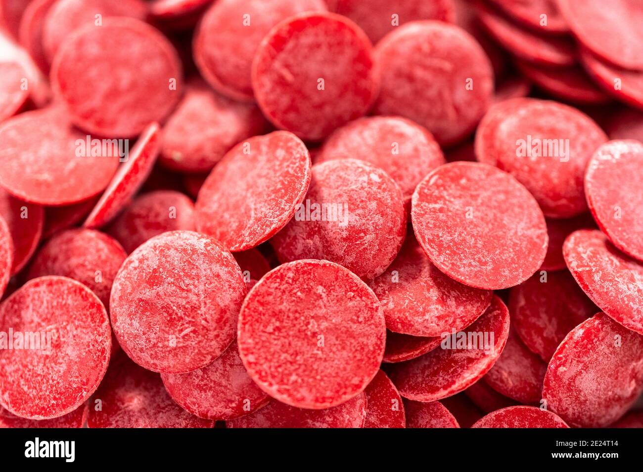Red round chocolate chips for melting chocolate shapes on a white ...