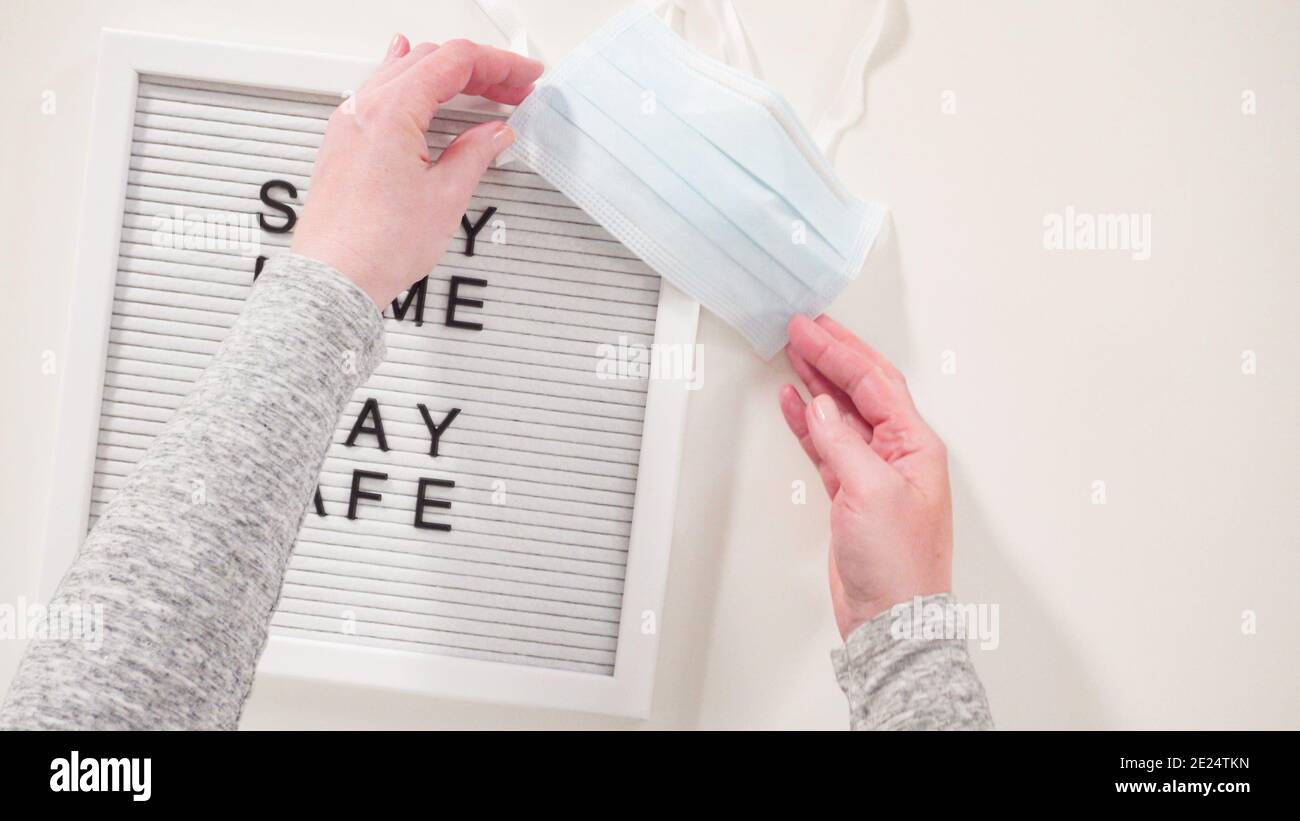 Flat lay. STAY HOME and STAY SAFE sign on message board with a blue ...