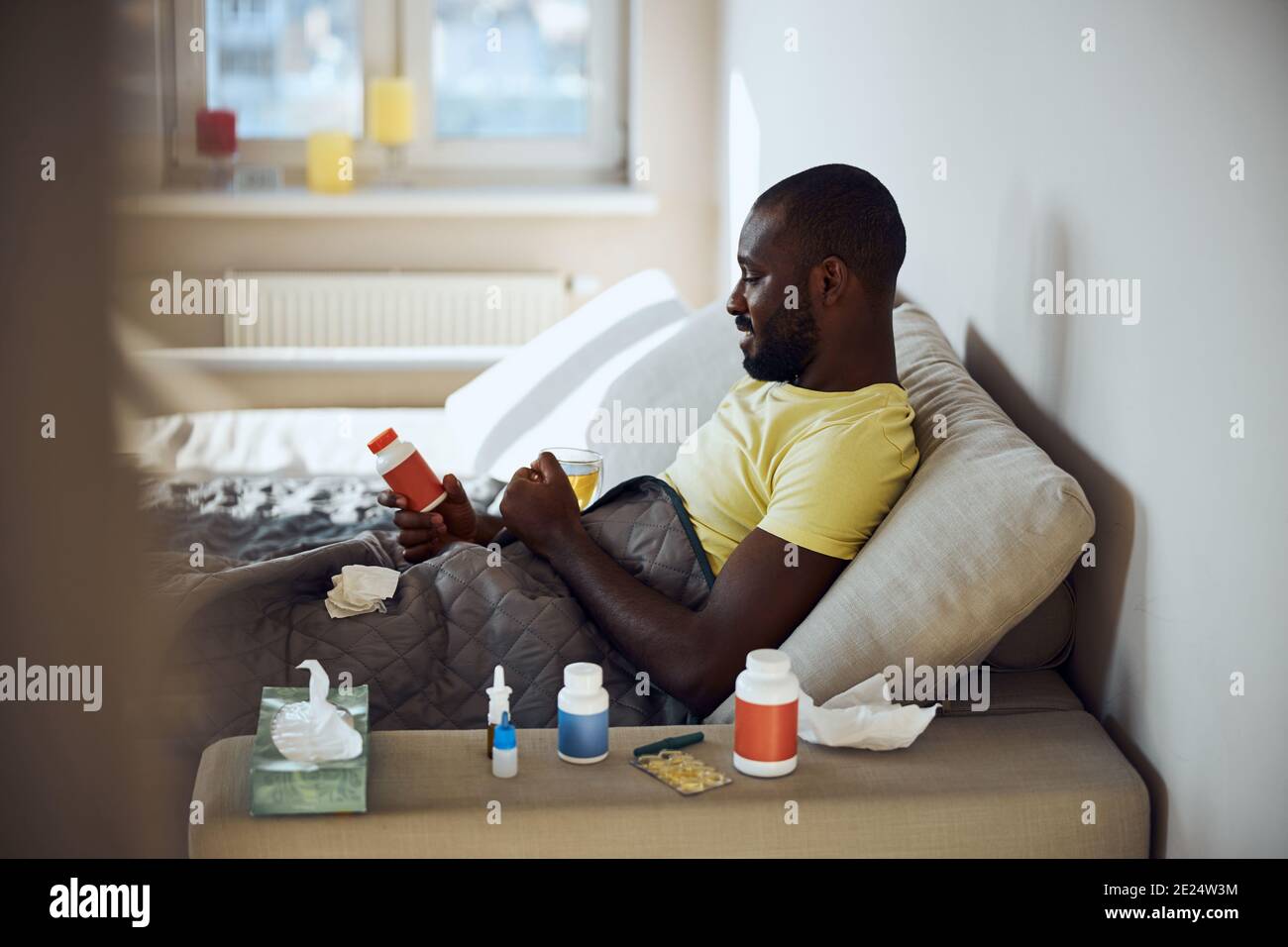 Afro-American person having a bed rest during illness Stock Photo - Alamy