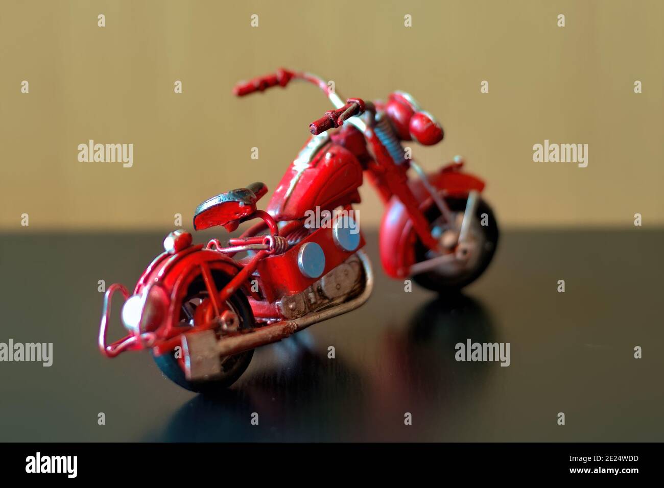 Miniature old red motorcycle model on a tablecaptured from behind Stock ...