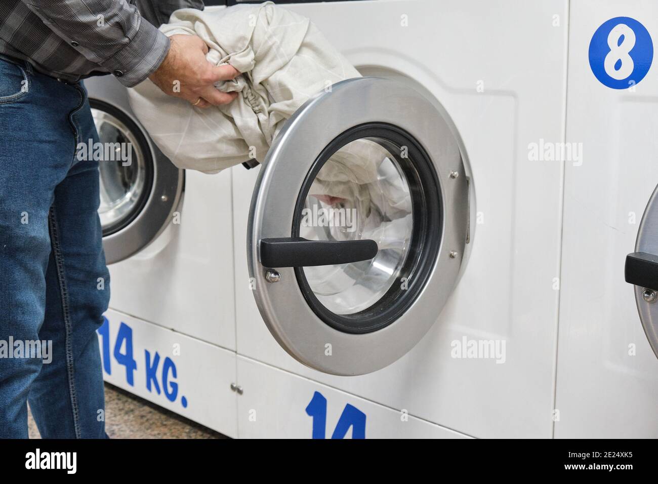 Cropped Hands Of Man Putting Clothes In Washing Machine At laundry ...
