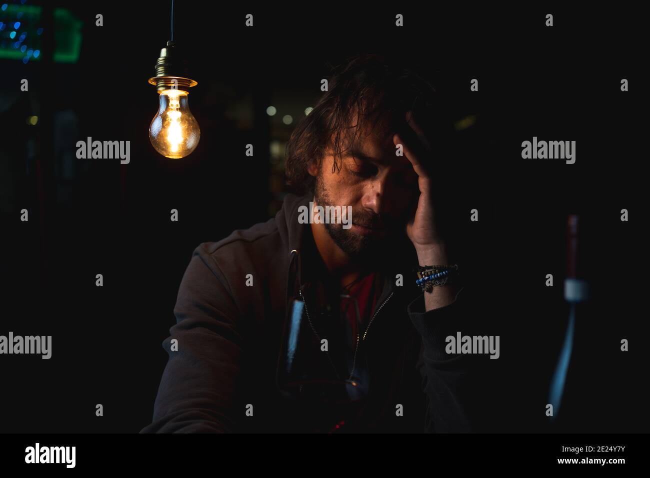 Drunken sad depressed man alone in a bar with glass full of alcohol ...