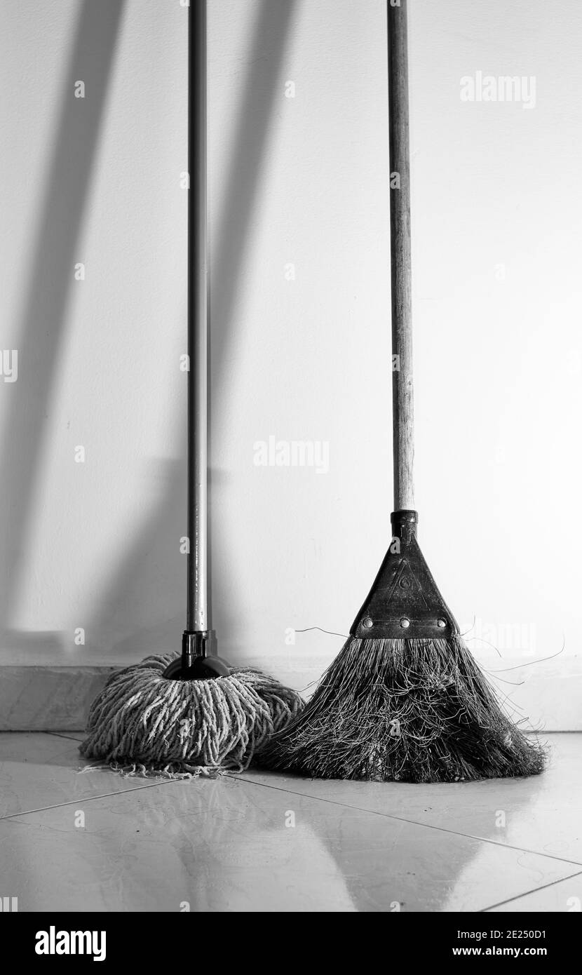 Grayscale vertical shot of cleaning broom and brush near a wall Stock ...