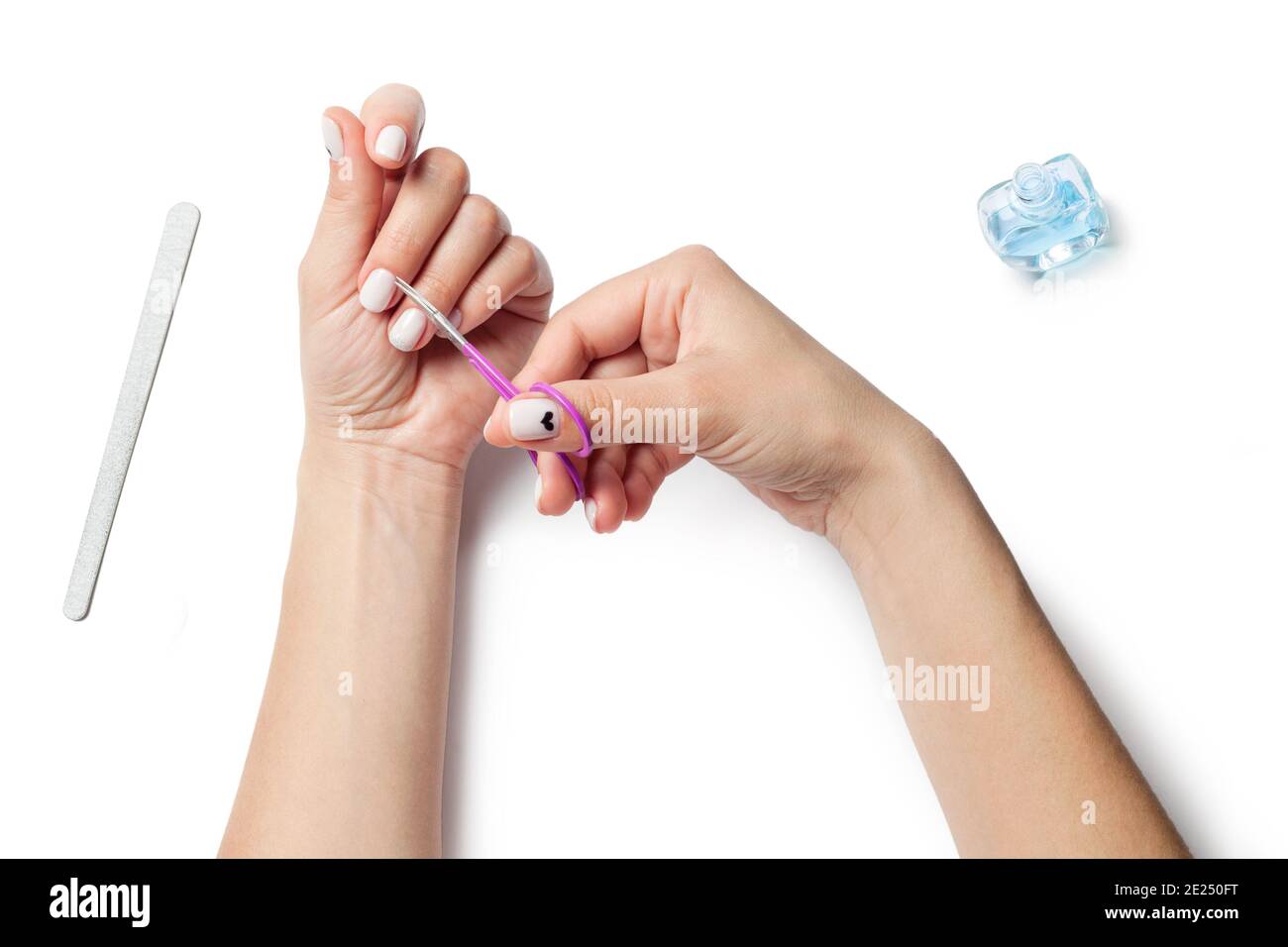 Female hands hold nail scissors, next to lay down devices for nail care ...