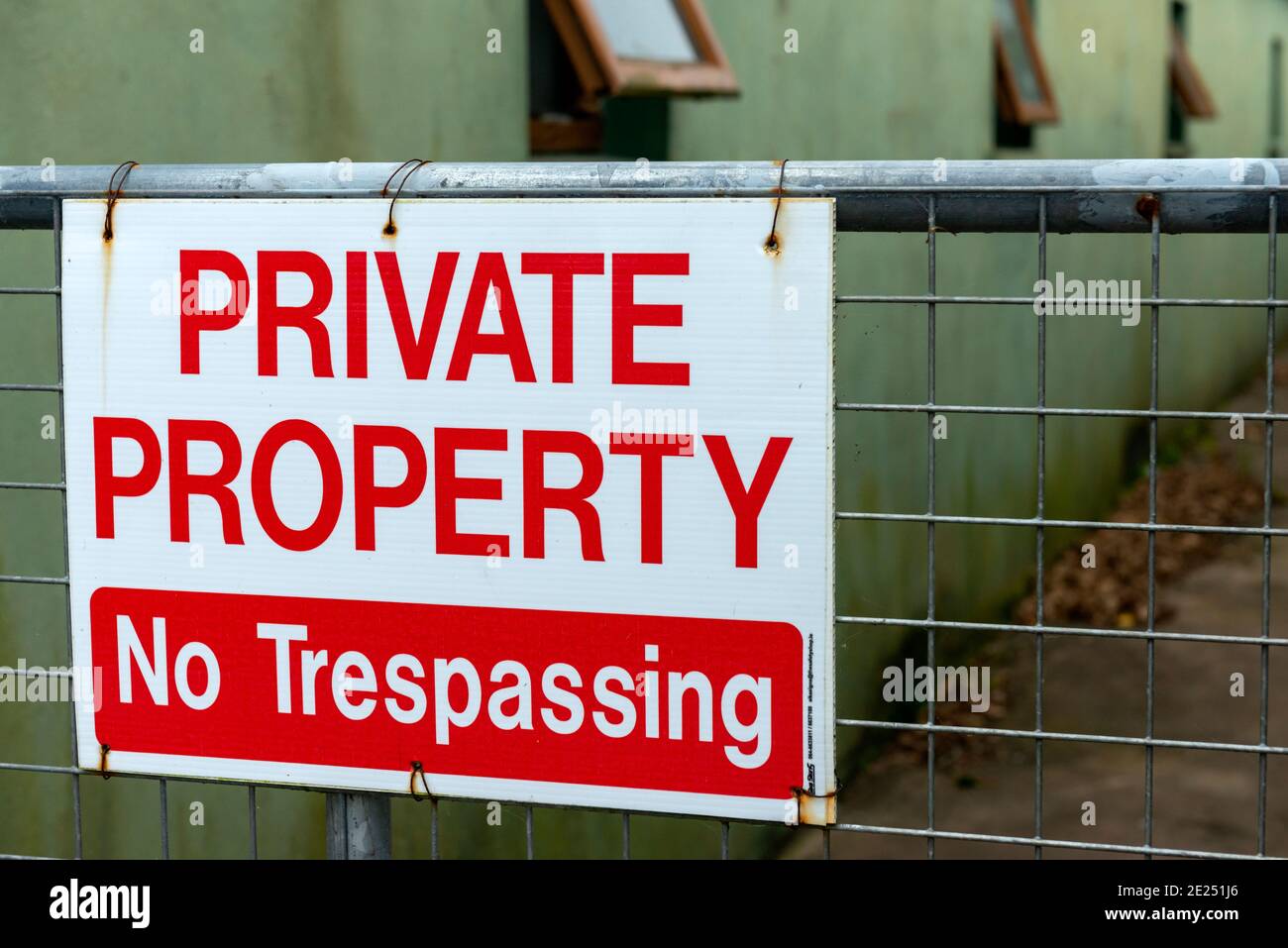 Private Property No Trespassing red warning sign on backyard fence of ...