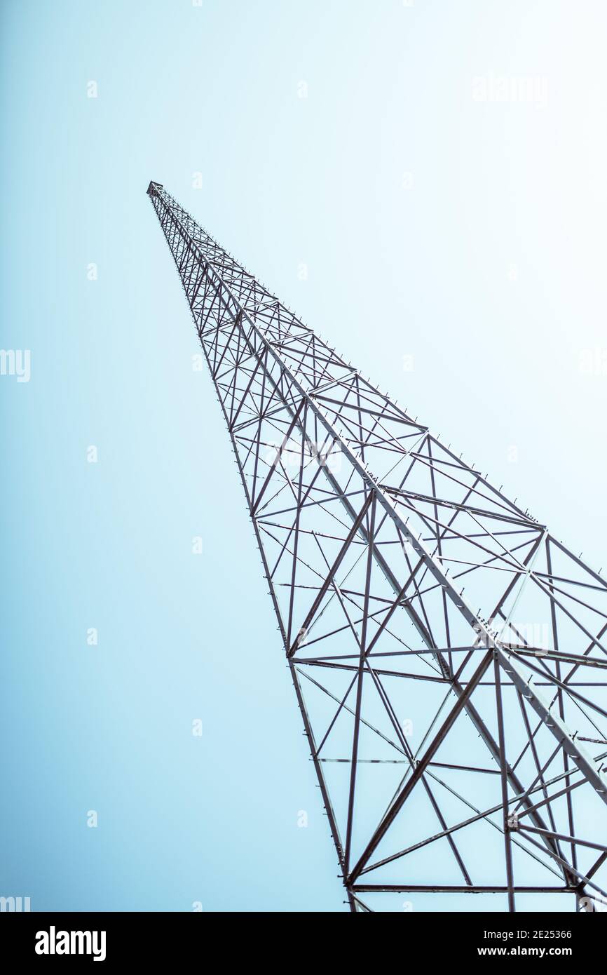 Low angle shot of power line structures against a blue sky background ...