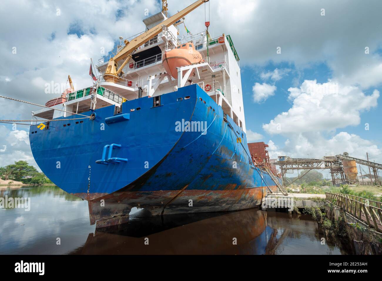 Ship moored at pier under loading operation. View from the aft stern ...