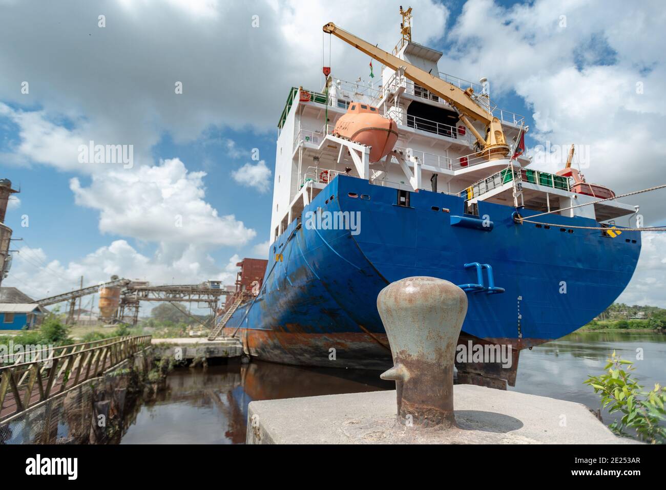 Ship moored at pier under loading operation. View from the aft stern ...