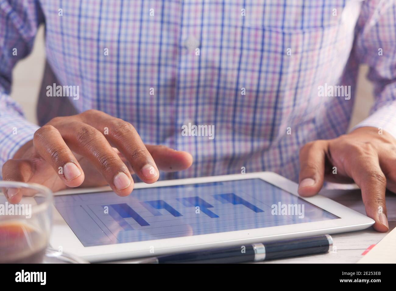 working on digital tablet at office desk, using self created chart ...