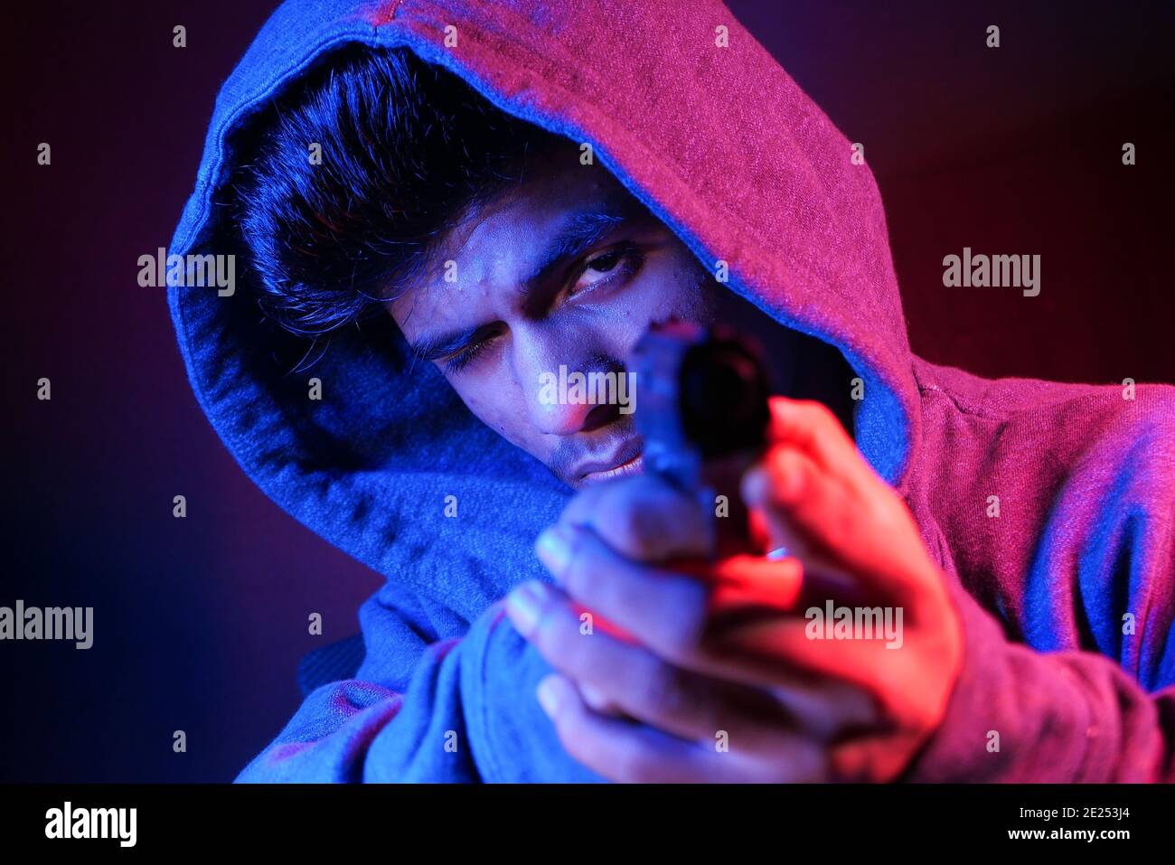 hooded man hand holding gun isolated on black Stock Photo - Alamy