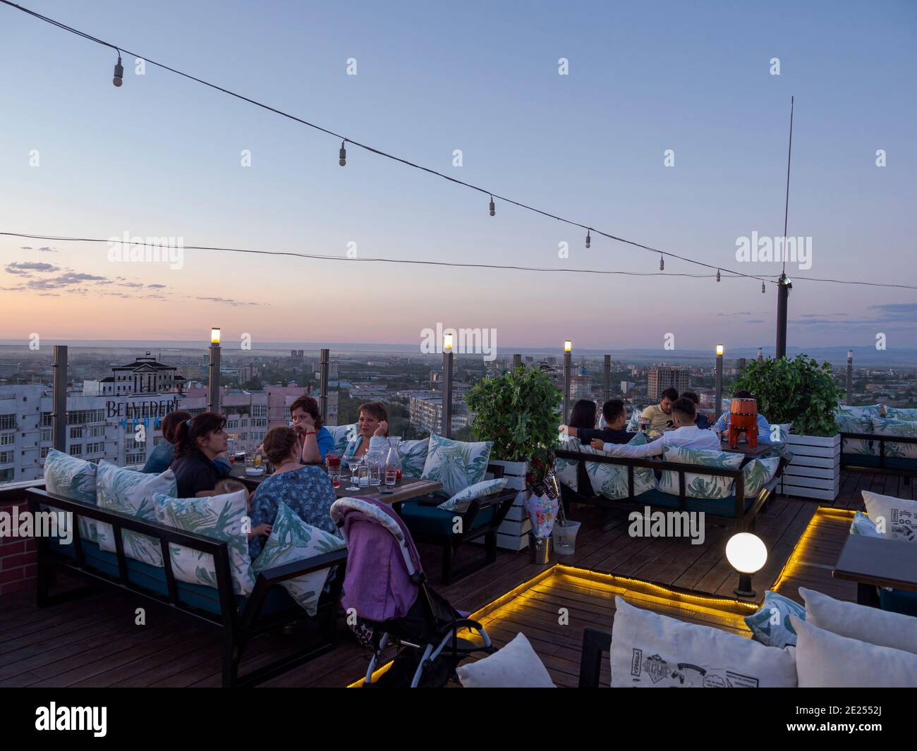 Locals having dinner in an open air restaurant on top of a high rise ...