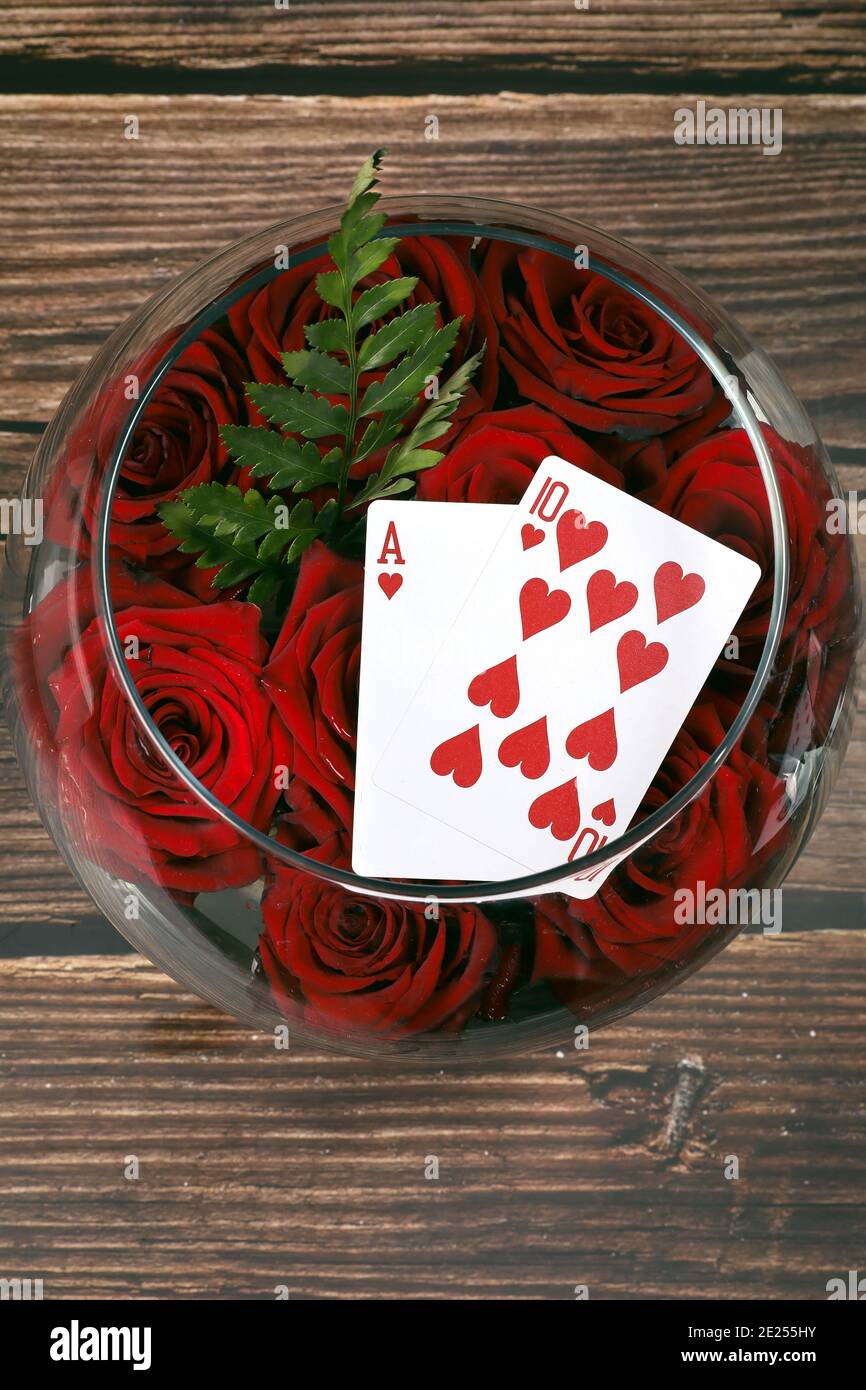 Top view A pair of aces in an aquarium with water and red roses against ...