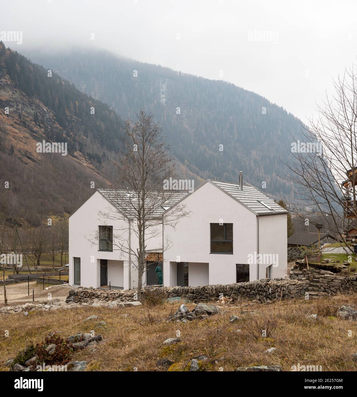 White house surrounded by nature, forest and fog in winter. Building in ...