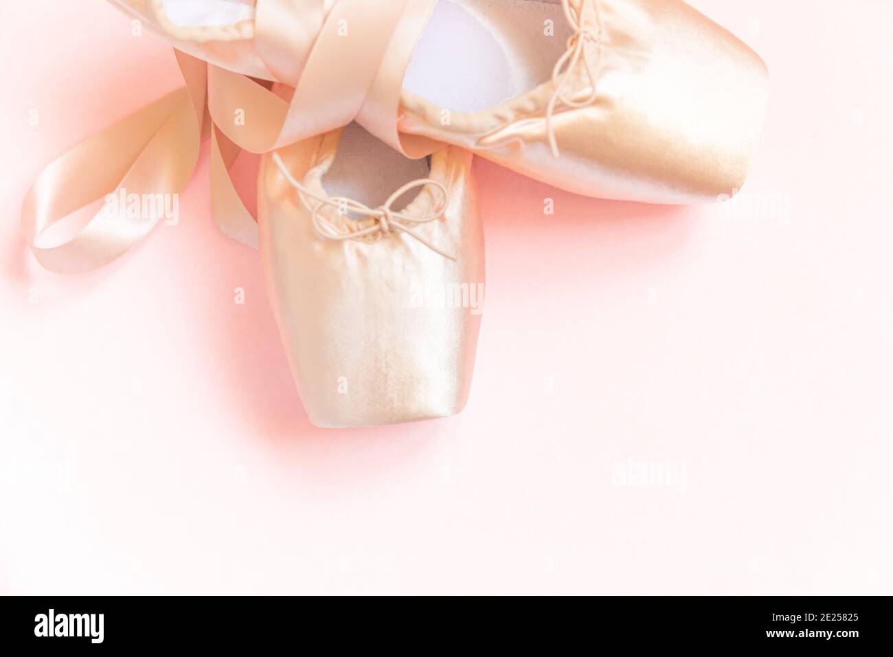 New pastel beige ballet shoes with satin ribbon isolated on pink ...