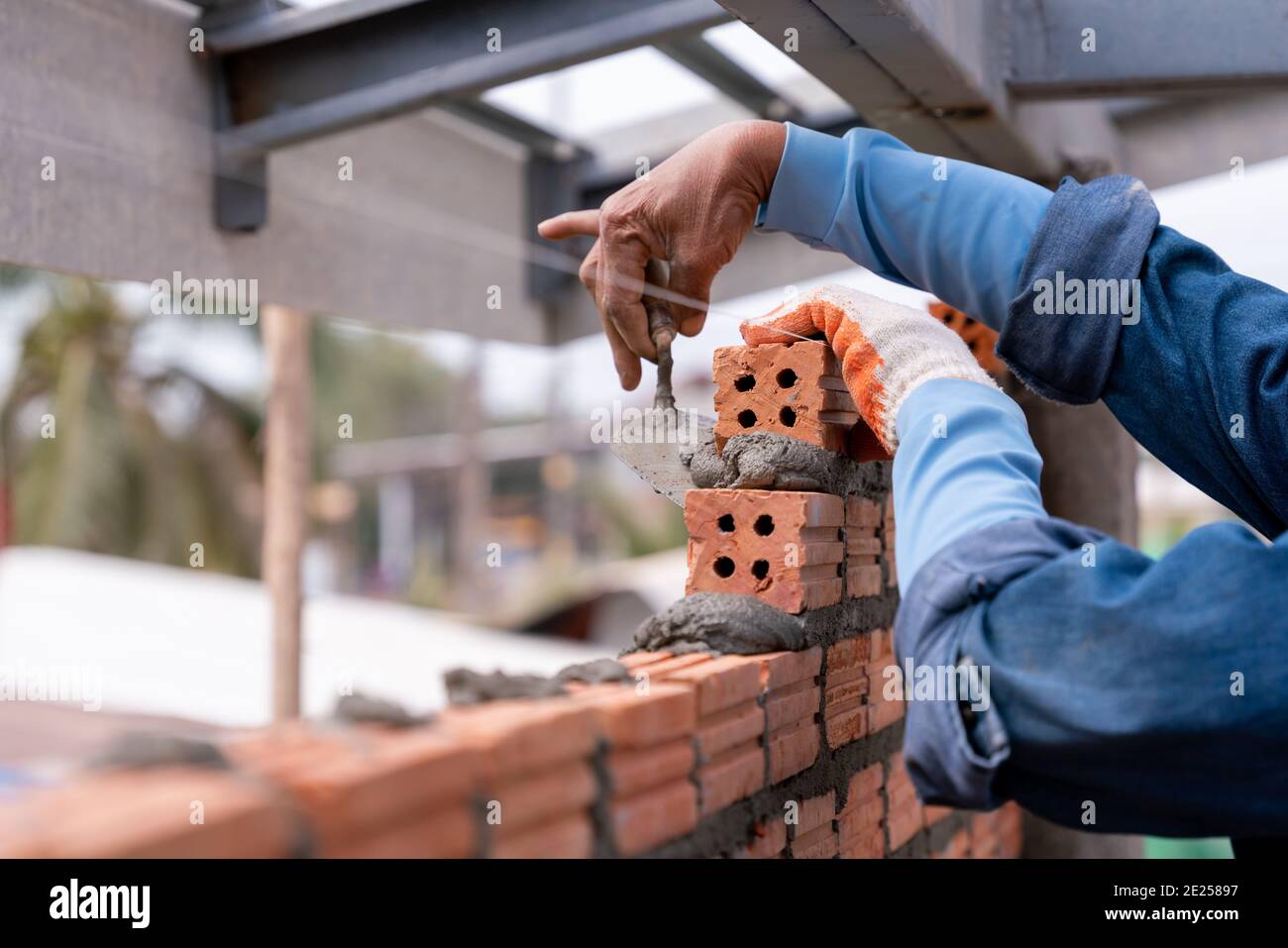 Close up hand of Bricklayer worker installing brick masonry on exterior ...