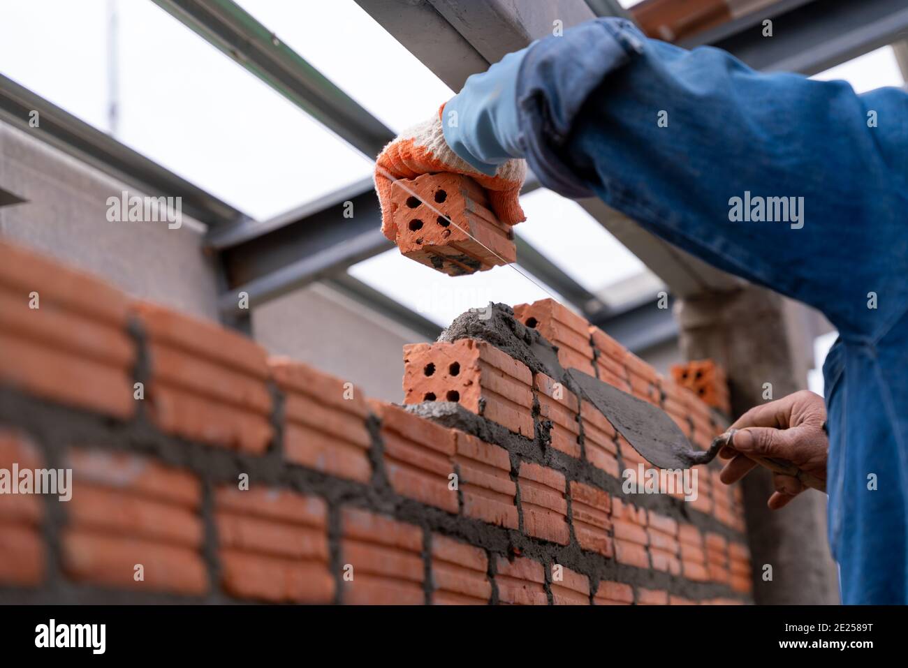 Close up hand of Bricklayer worker installing brick masonry on exterior ...