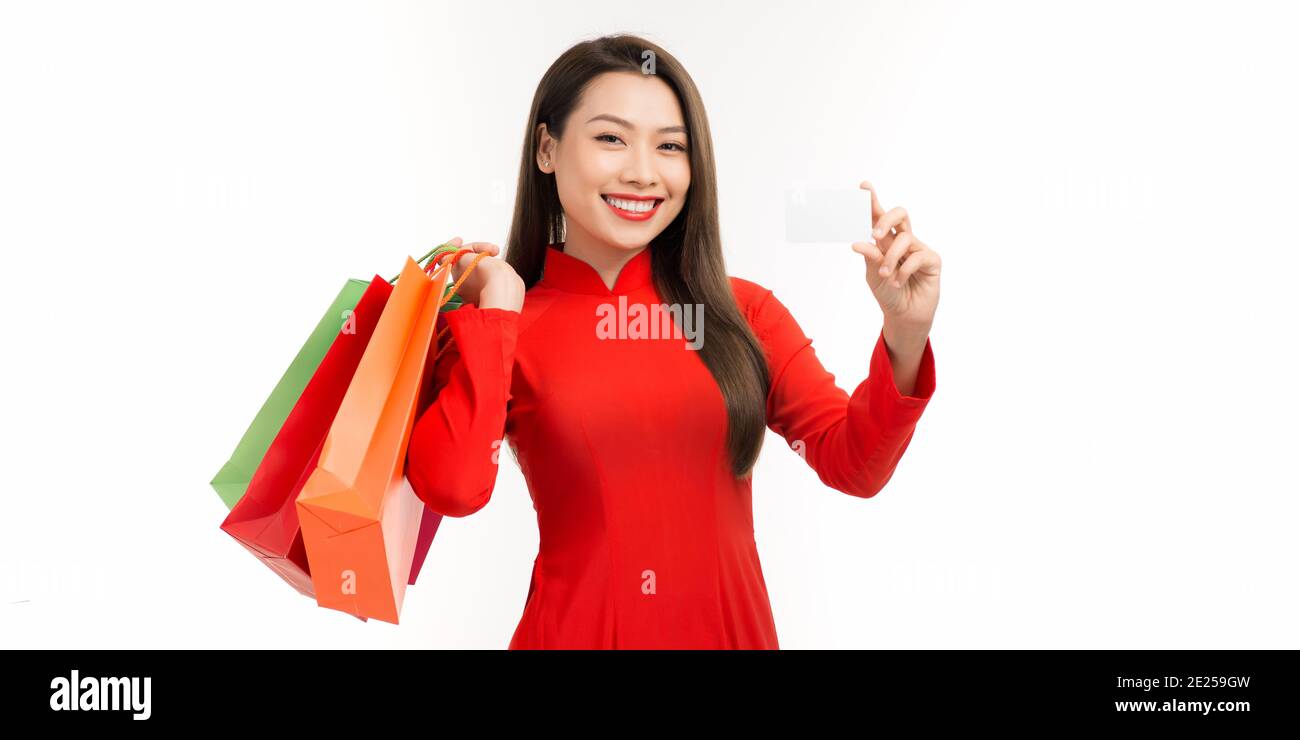 Asian woman in ao dai traditional red dress holding shopping bag and ...