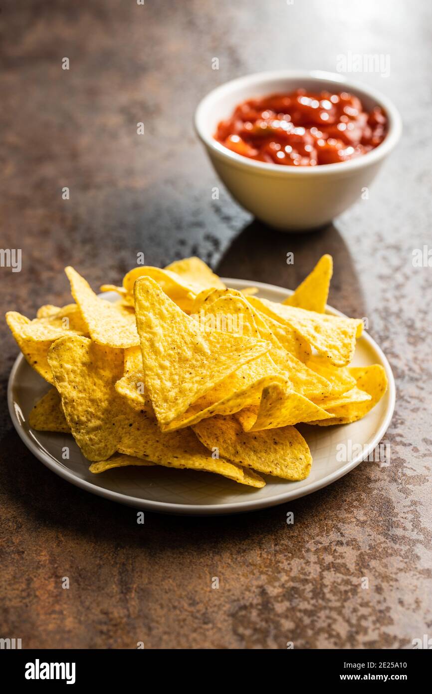 Tortilla chips and red tomato salsa dip. Mexican nacho chips on brown ...