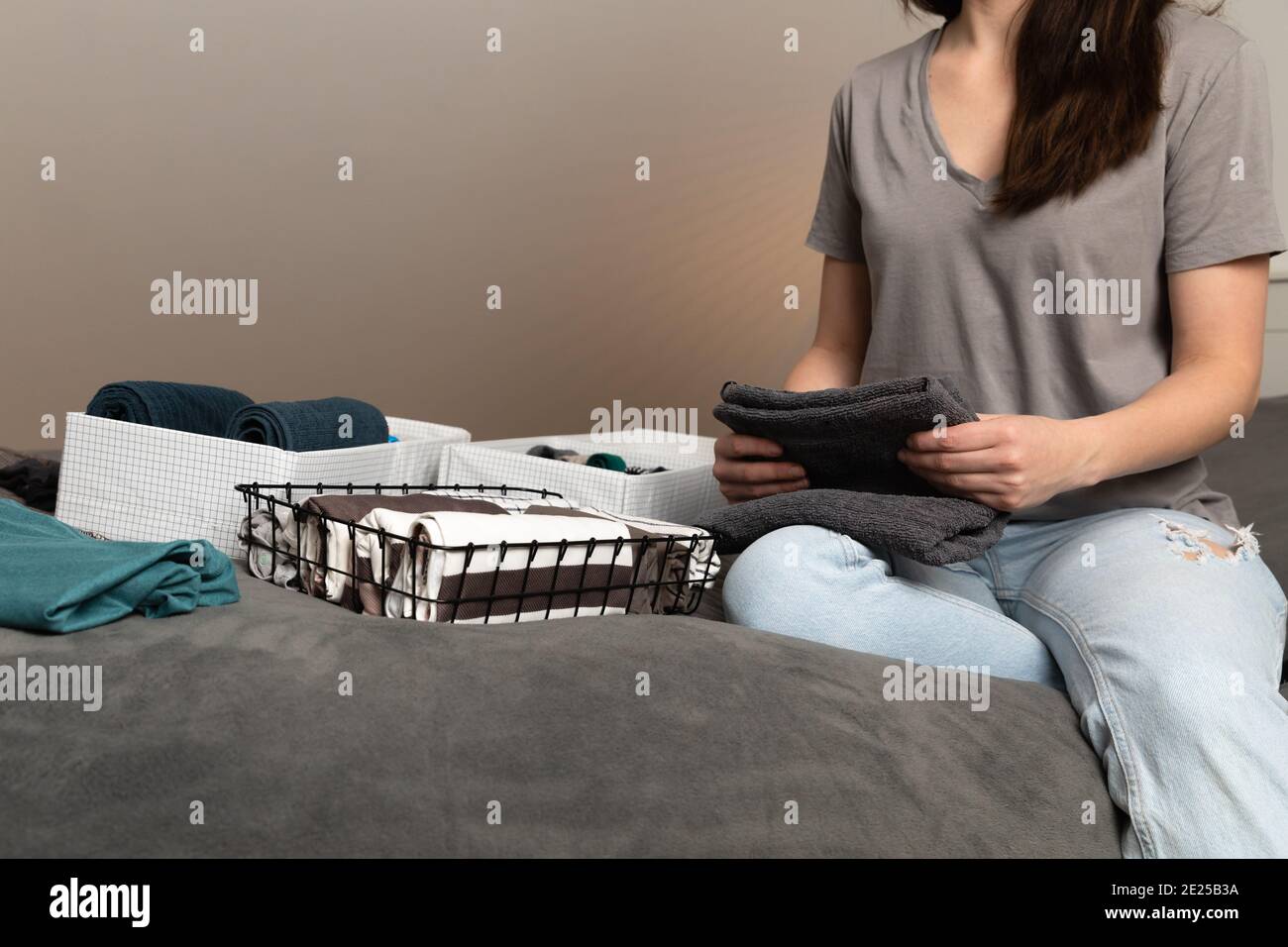 Vertical storage of clothing.Women organize clothes in a modern bedroom ...