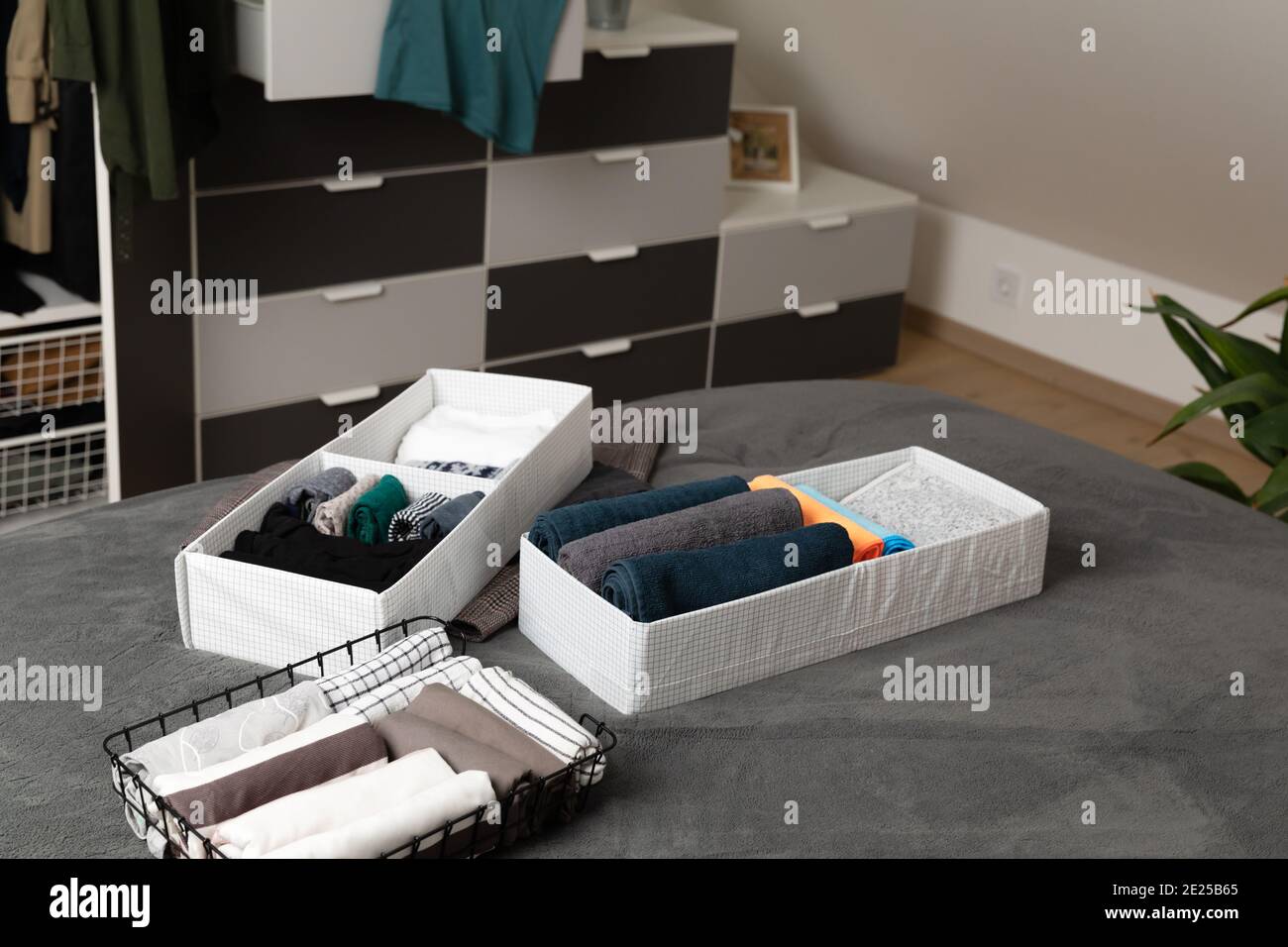 Vertical storage of clothing. Sorted clothes in baskets and shelves in ...