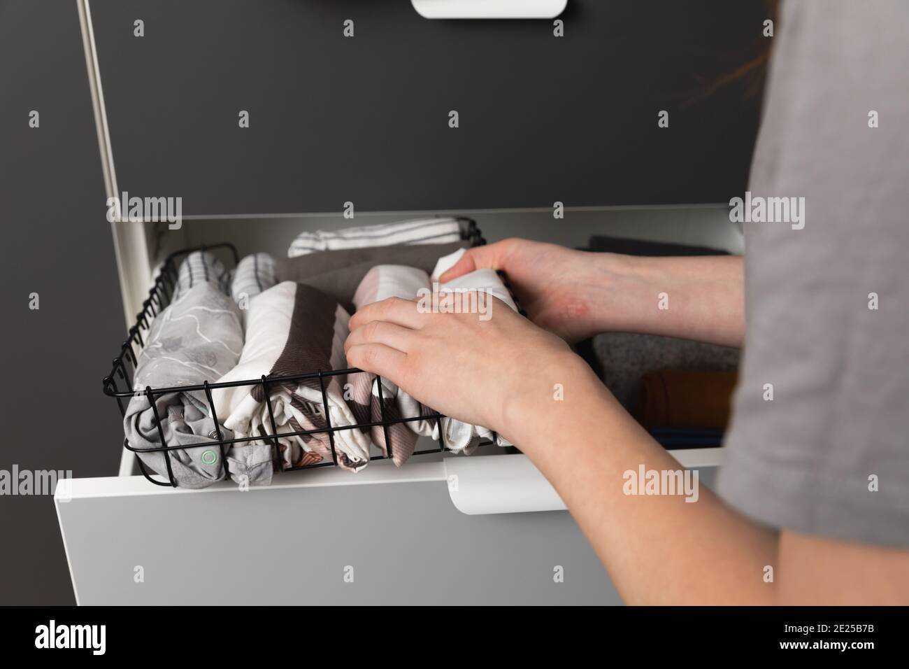 Vertical storage of clothing.Women organize clothes in a modern bedroom ...