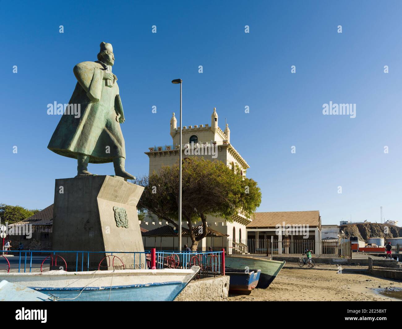 Traditional fishing boats on the beach of the harbor and statue of ...