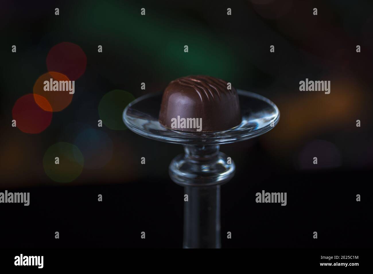 Chocolate placed on a small glass bowl with a blurry light on the ...