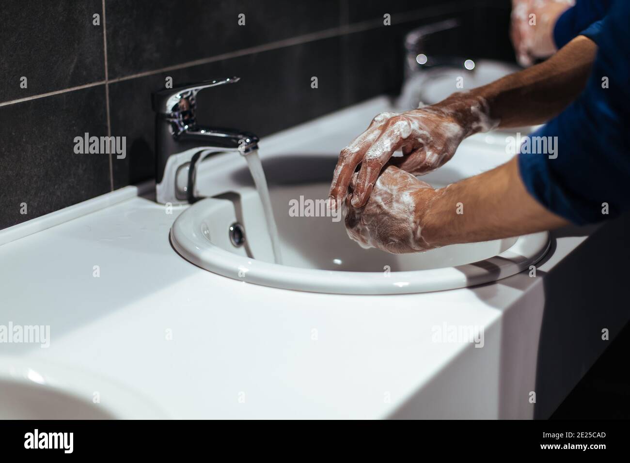 close up. young people wash their hands in a public restroom Stock ...