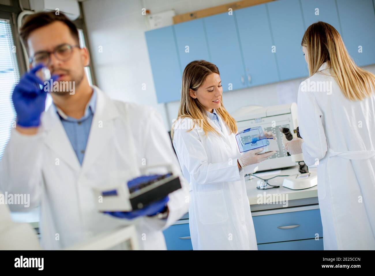 Handsome researcher in protective workwear standing in the laboratory ...