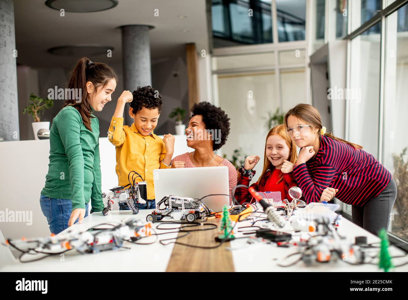 Group of happy kids with their African American female science teacher ...