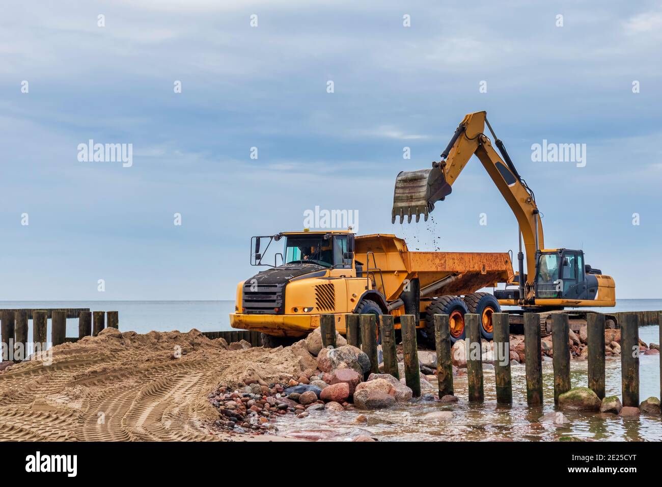 Industrial truck loader excavator moving sand and unloading it into a ...
