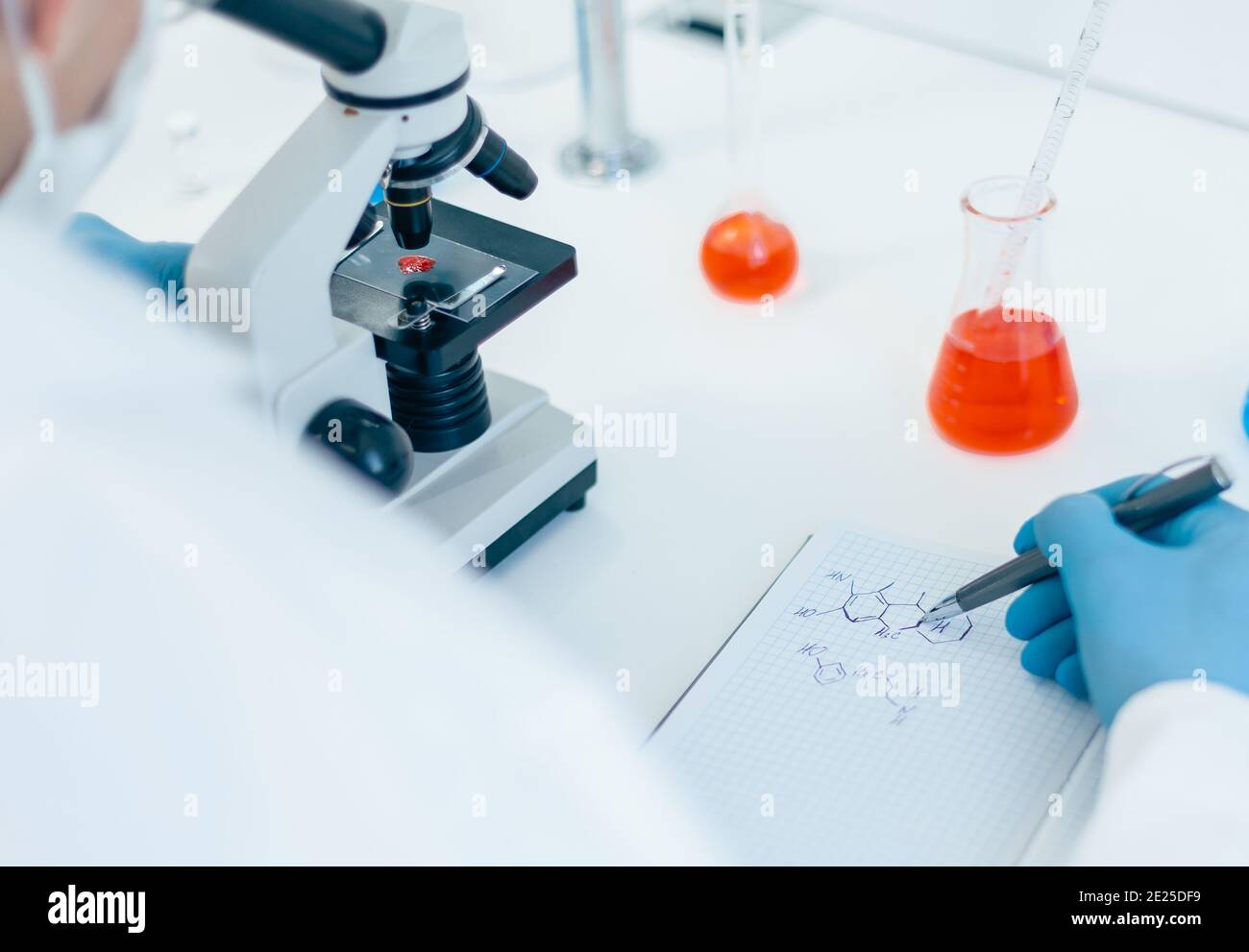 close up. scientist looking at a drop of blood through a microscope ...