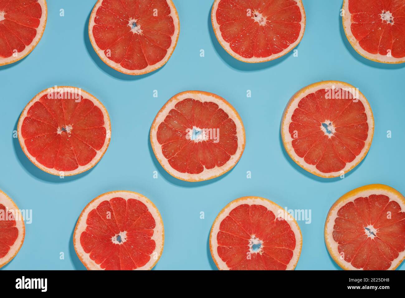 Patterns of slices of juicy Grapefruit on a blue background, a ...