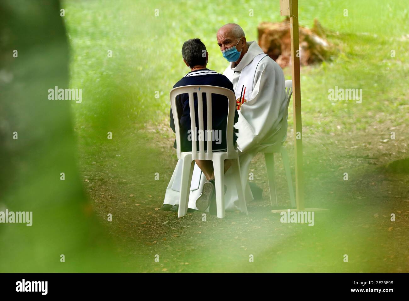Catholic church during covid-19 epidemic. A penitent confessing his ...