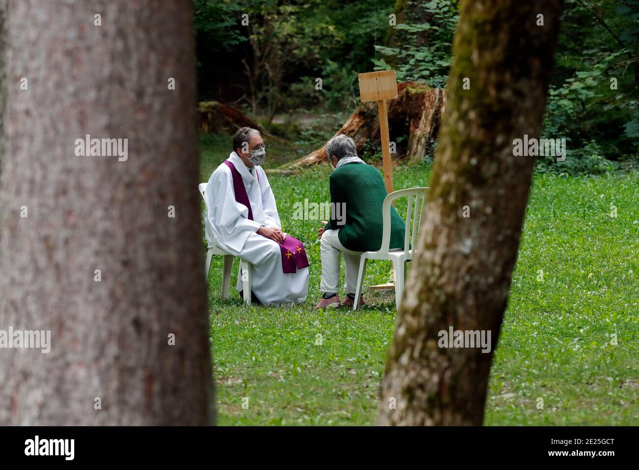 Catholic church during covid-19 epidemic. A penitent confessing his ...