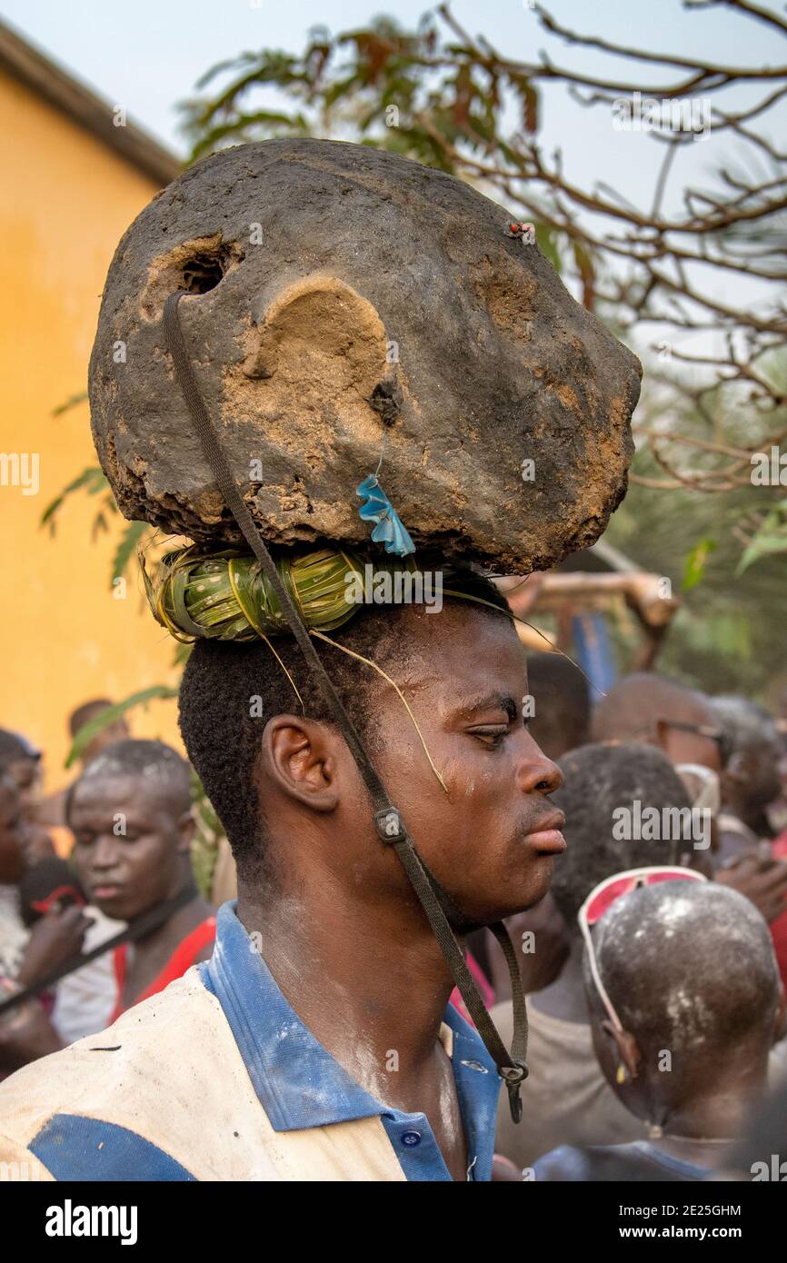 Young man carrying a magic carving over his head at a voodoo funeral ...
