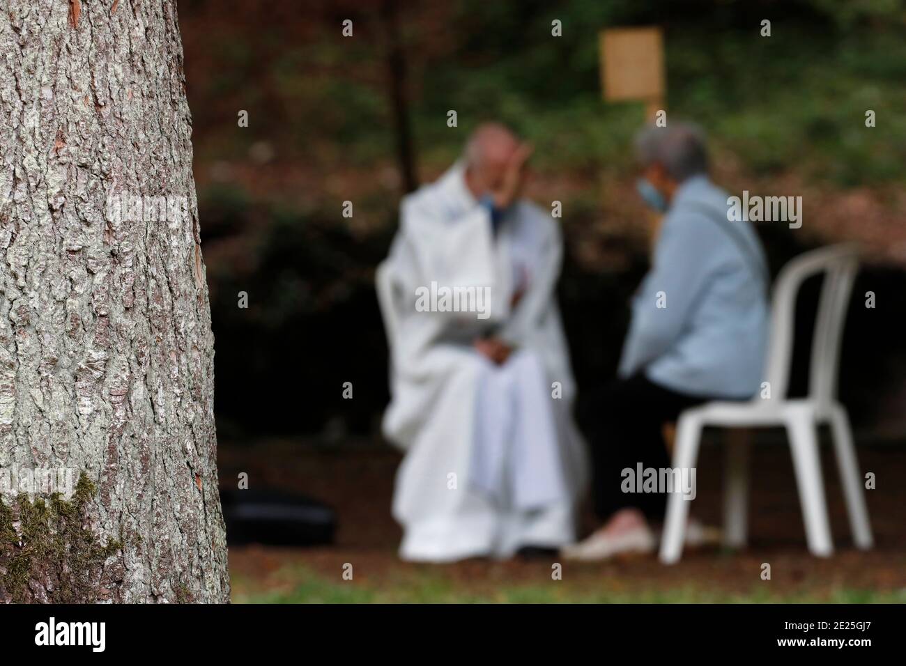 Catholic church during covid-19 epidemic. A penitent confessing his ...