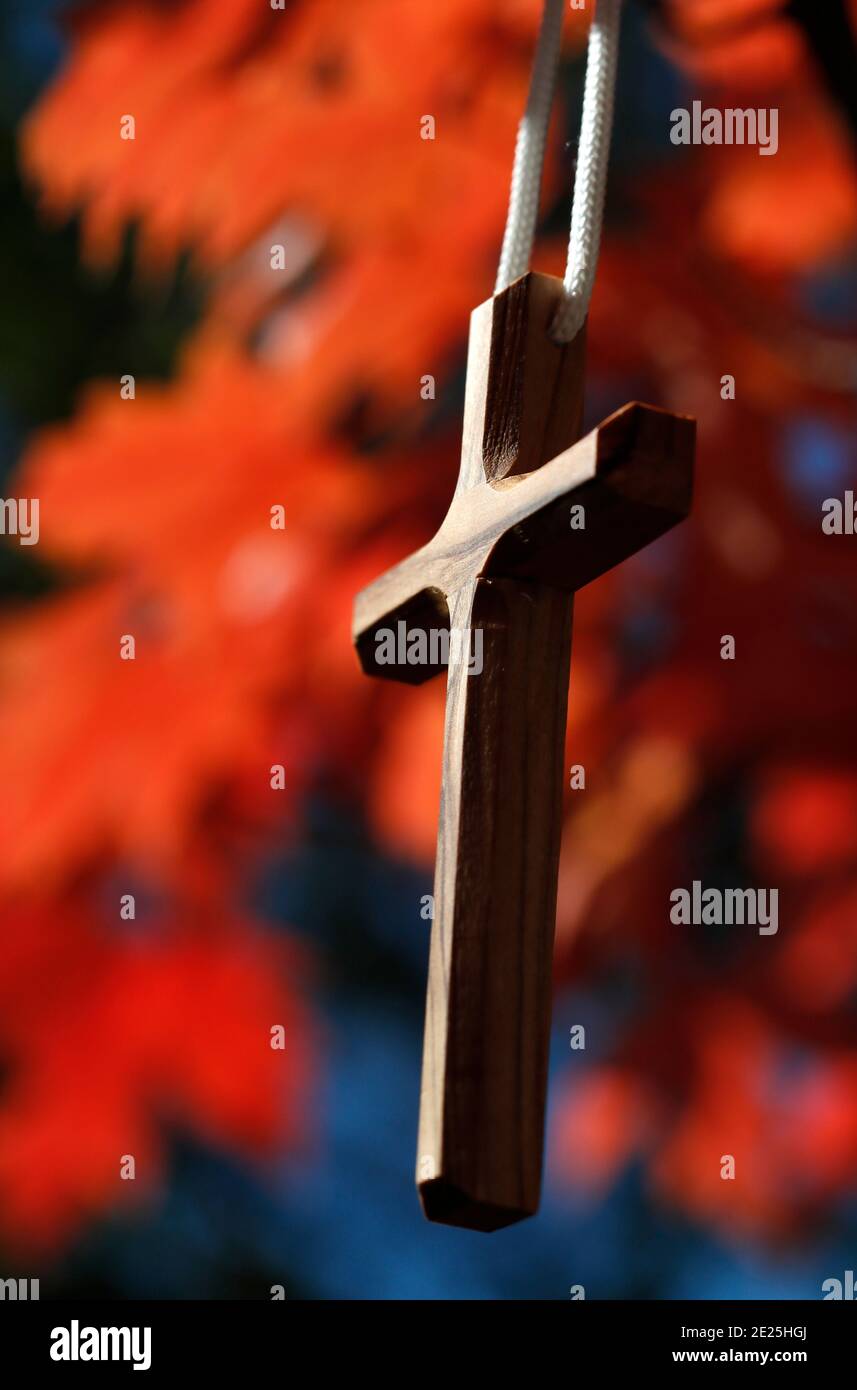 Christian cross hanging on a tree branch with red leaves. Autum. France ...