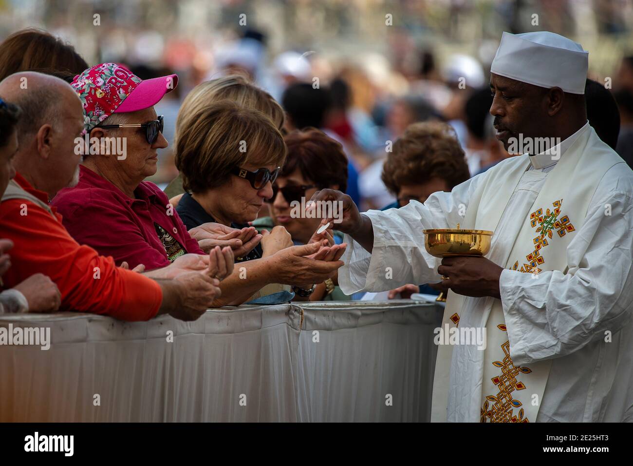 A Priest gives holy communion to the faithful during Pope Francis's ...